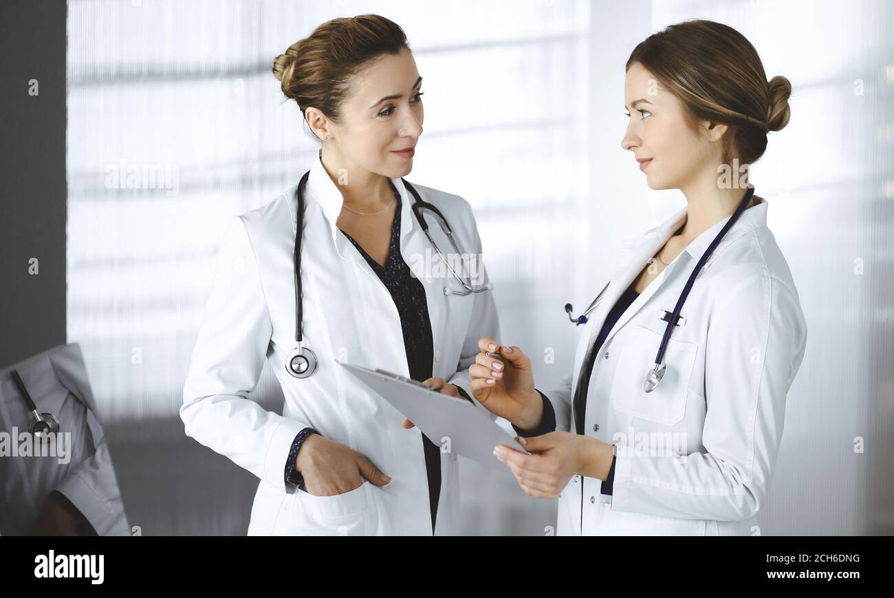 Two female physicians are discussing their patient's medical tests ...