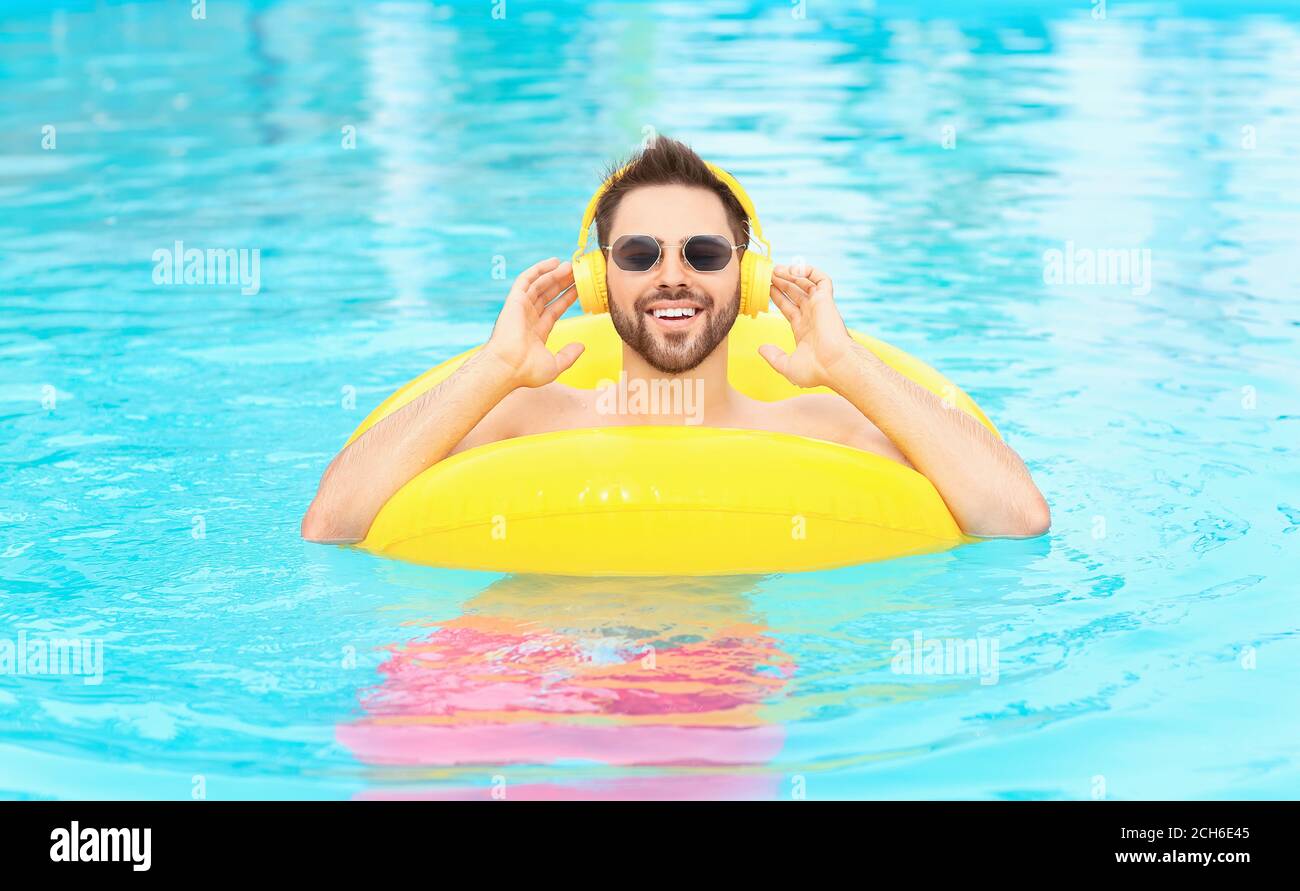 Young man listening to music in swimming pool Stock Photo - Alamy