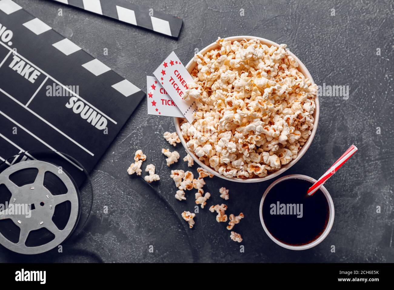 Popcorn, cola, movie clapper and cinema tickets on dark background ...