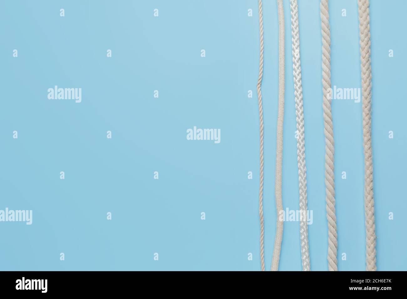 Long ropes on color background Stock Photo - Alamy