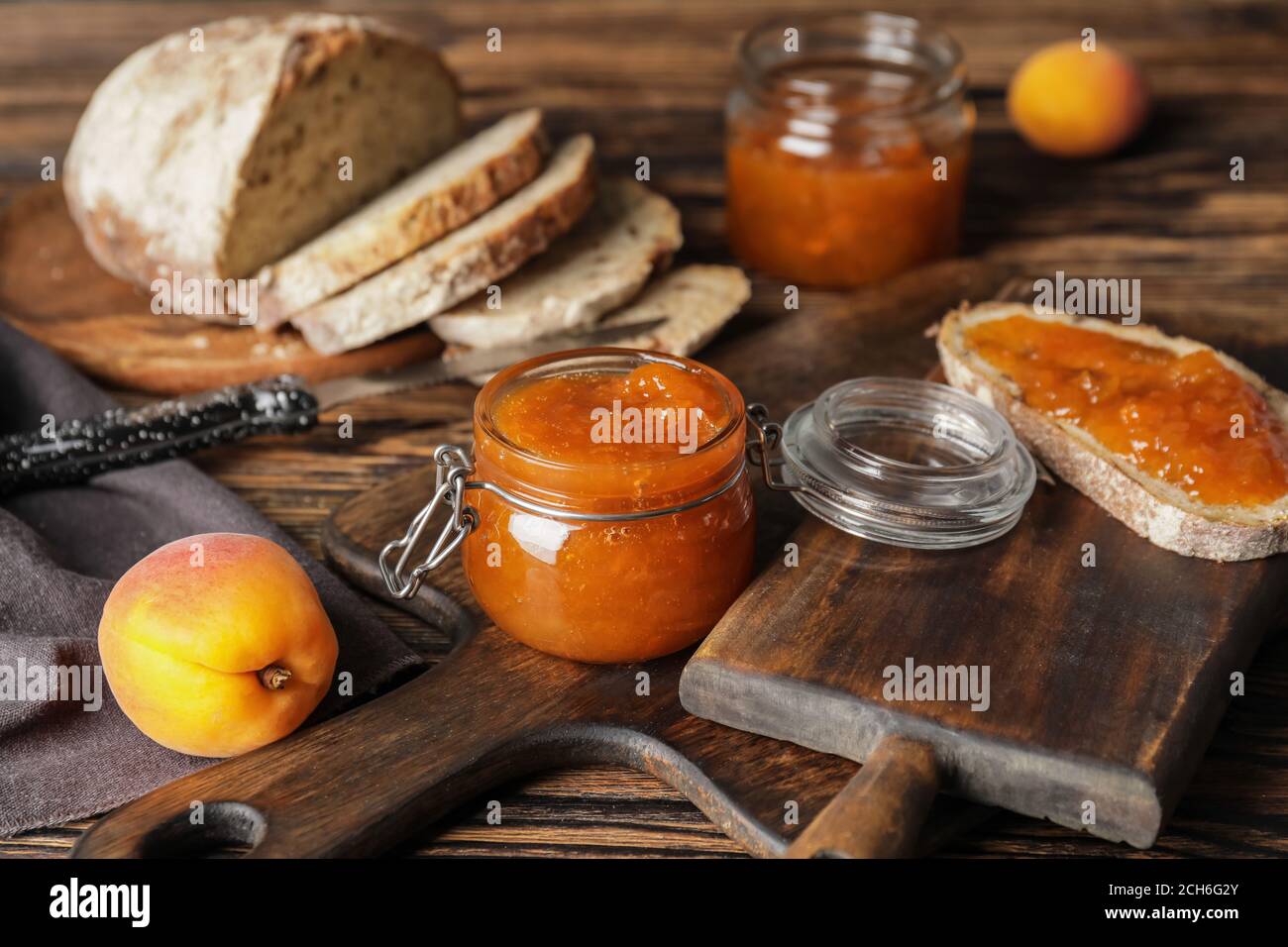 Jar of tasty apricot jam and bread on table Stock Photo - Alamy