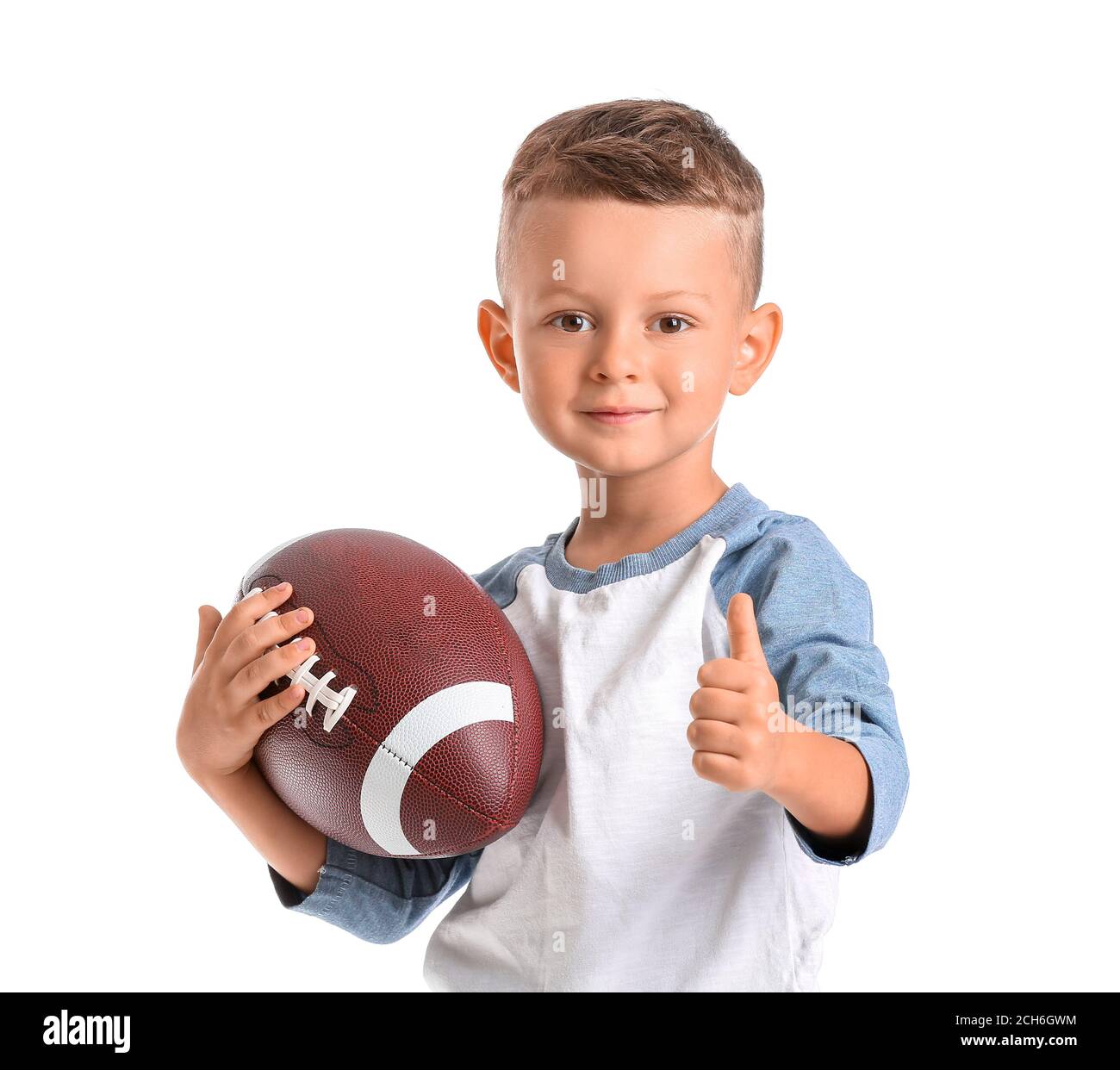 Little boy with rugby ball showing thumb-up on white background Stock ...