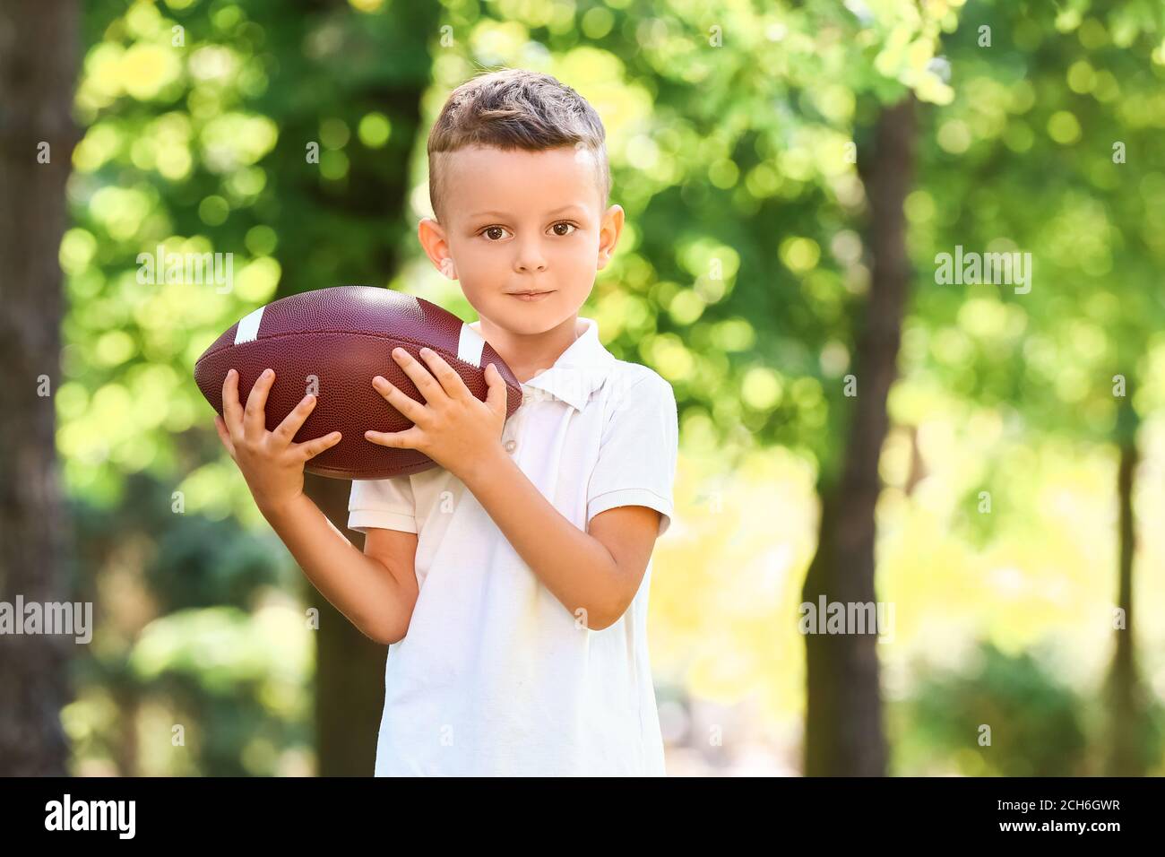 Little boy playing American football outdoors Stock Photo - Alamy