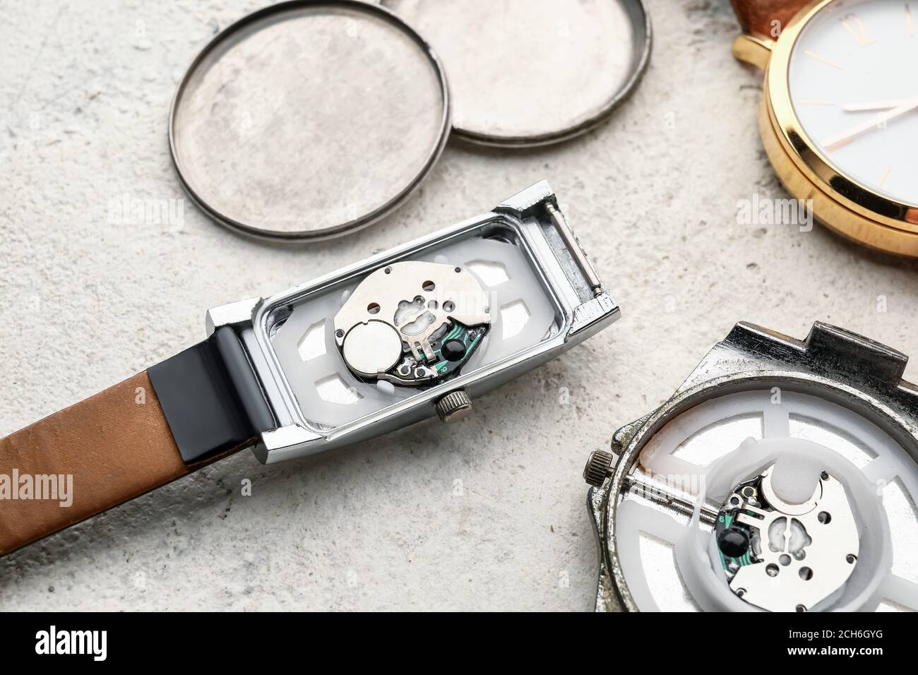 Different broken watches on light background Stock Photo - Alamy