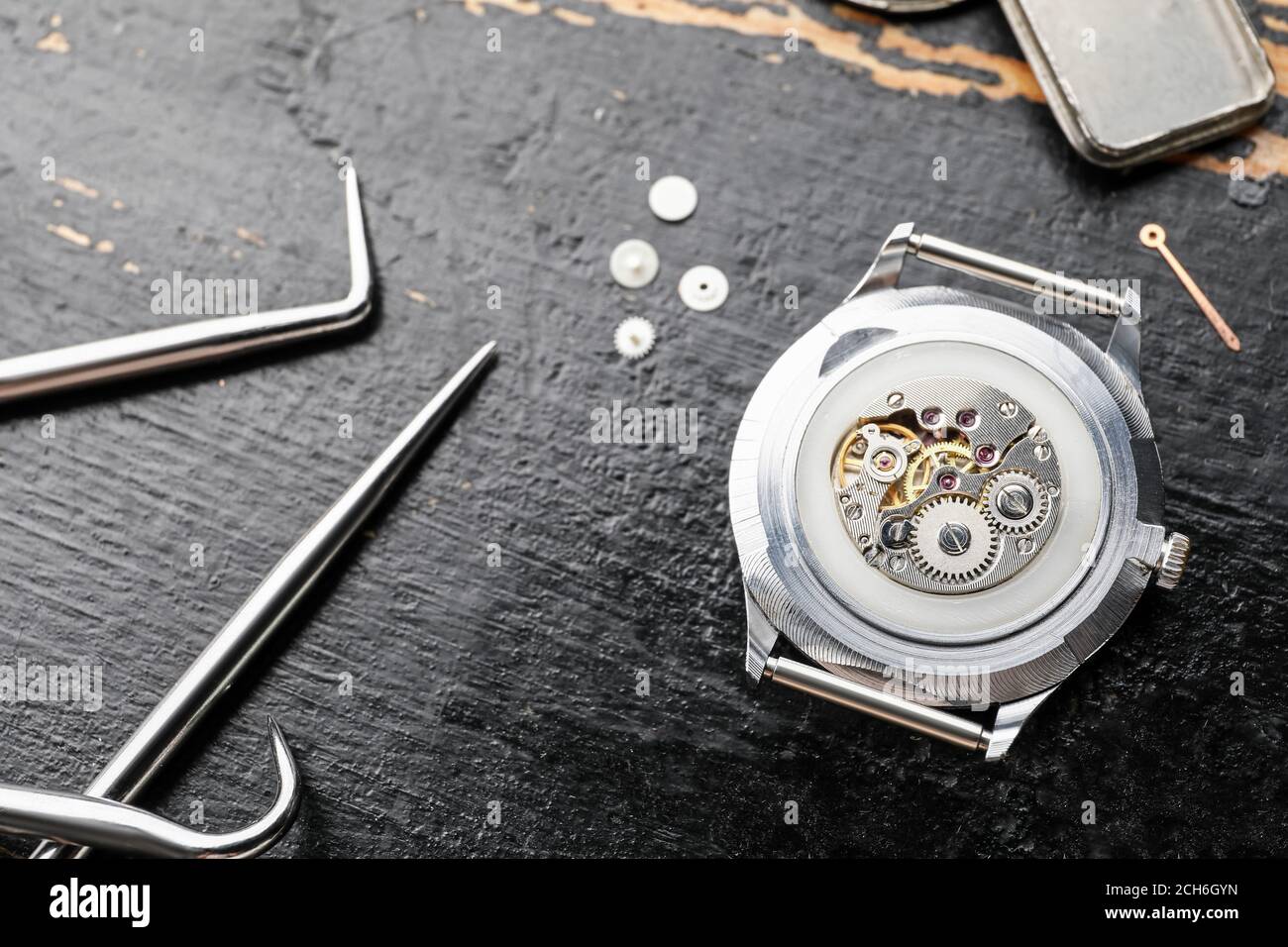 Watch and tools for repair on dark background Stock Photo - Alamy