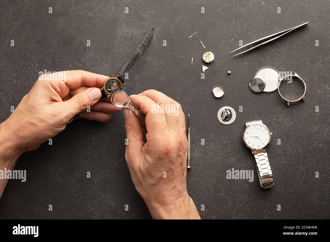 Clockmaker repairing broken watch at table Stock Photo - Alamy