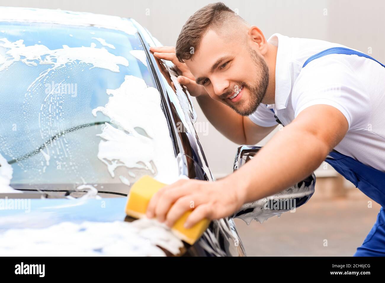 Male worker washing car outdoors Stock Photo - Alamy