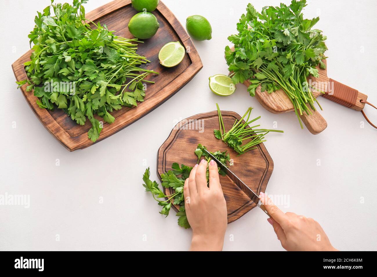 Woman cutting fresh parsley on white background, top view Stock Photo ...