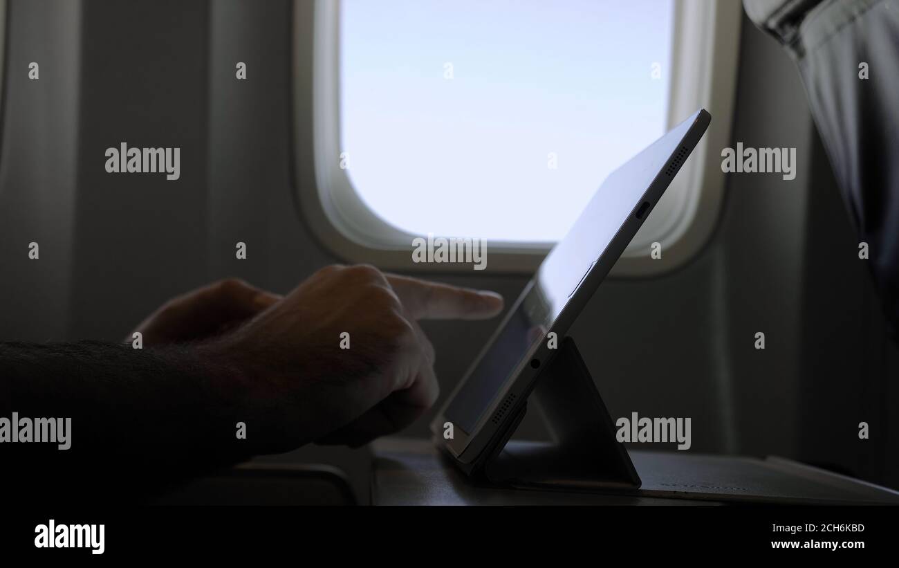 Tablet in hands airplane hi-res stock photography and images - Alamy