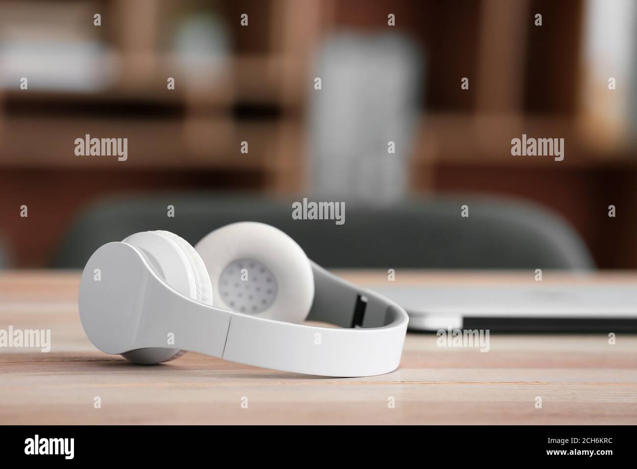 Modern headphones on table in office Stock Photo - Alamy