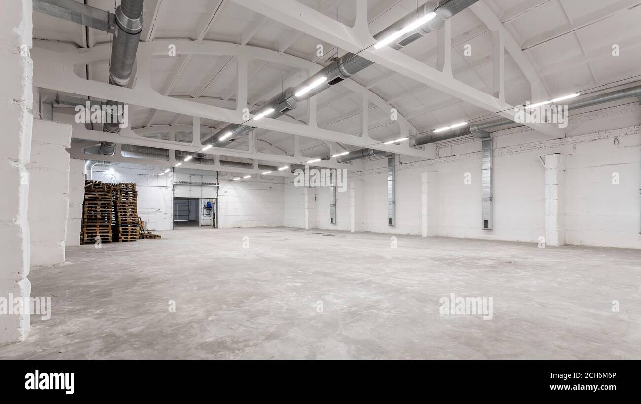 Industrial building interior with white brick walls, concrete floor and ...