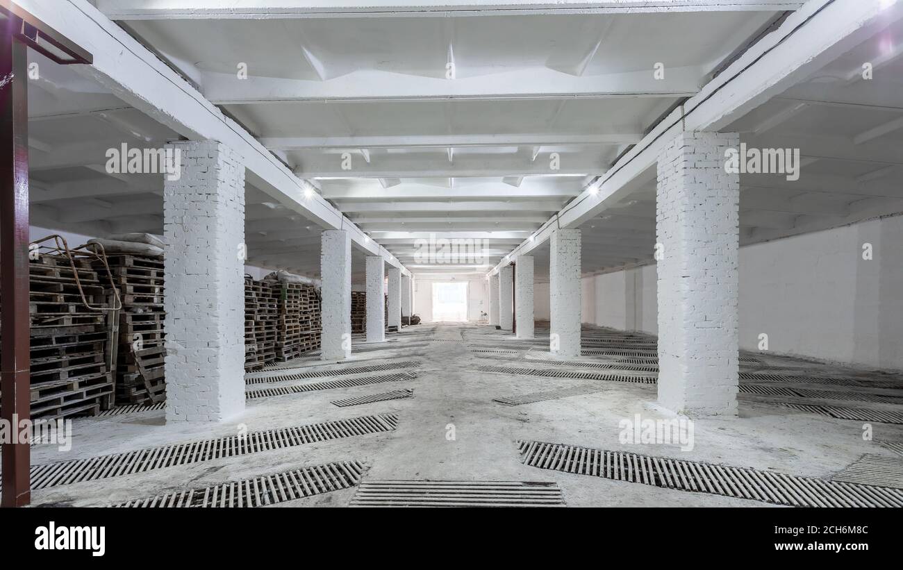 Industrial building interior with white brick walls, concrete floor ...