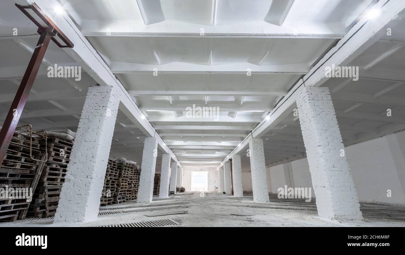 Industrial building interior with white brick walls, concrete floor ...