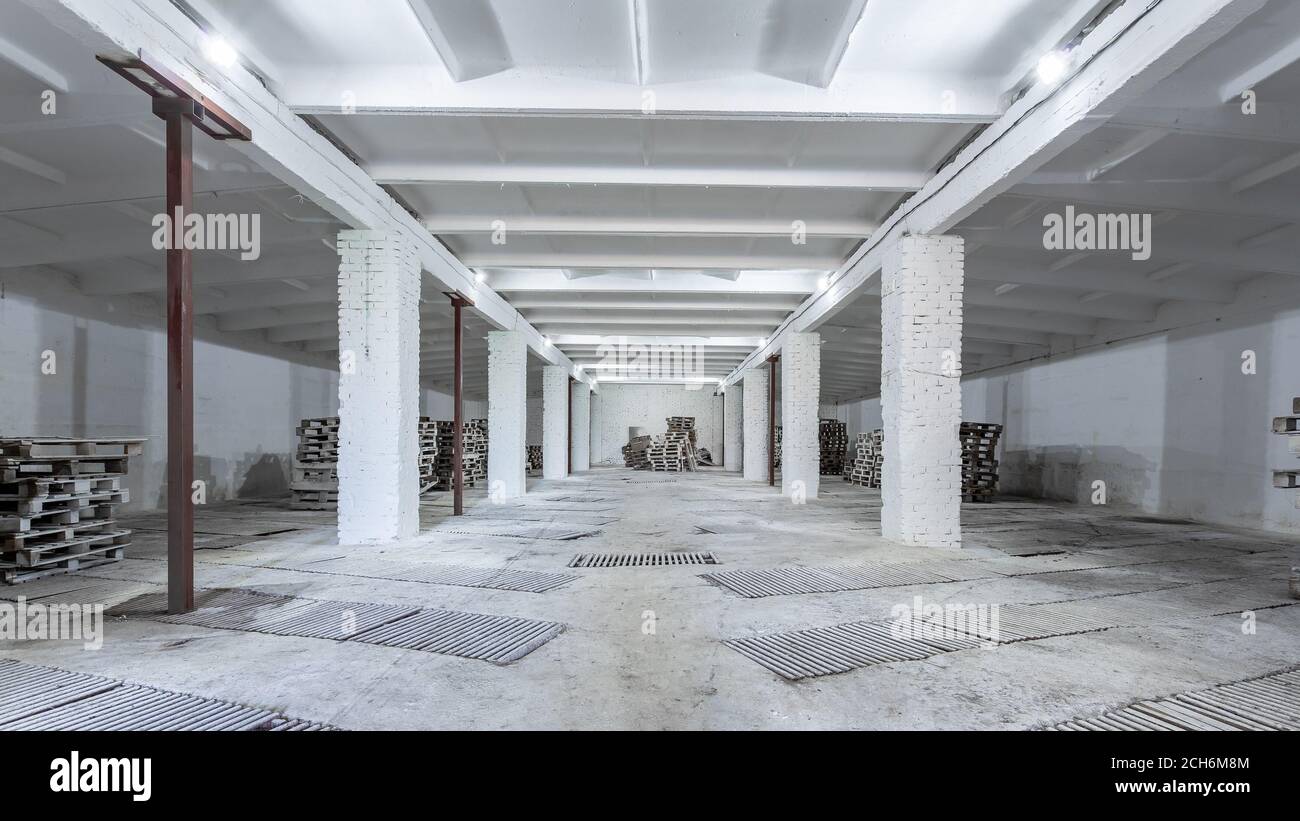 Industrial building interior with white brick walls, concrete floor and ...