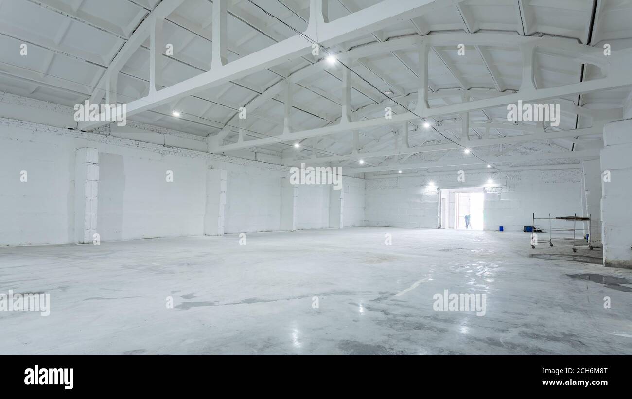 Industrial building interior with white brick walls, concrete floor and ...