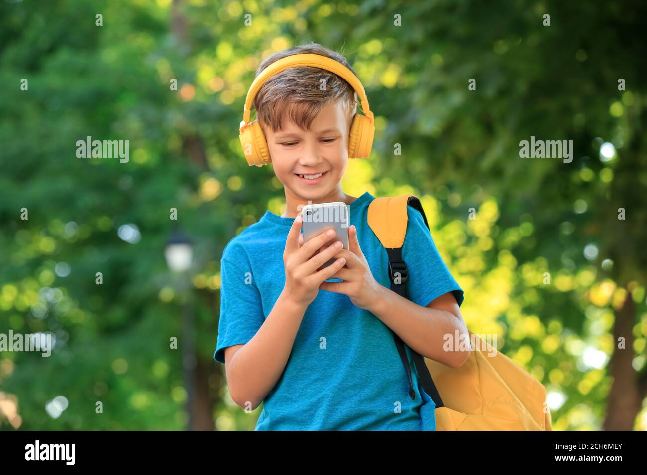 Little boy listening to music in park Stock Photo - Alamy