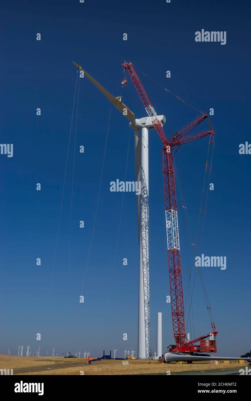 Giant crane lifting wind turbine blade to attach to nacelle during ...