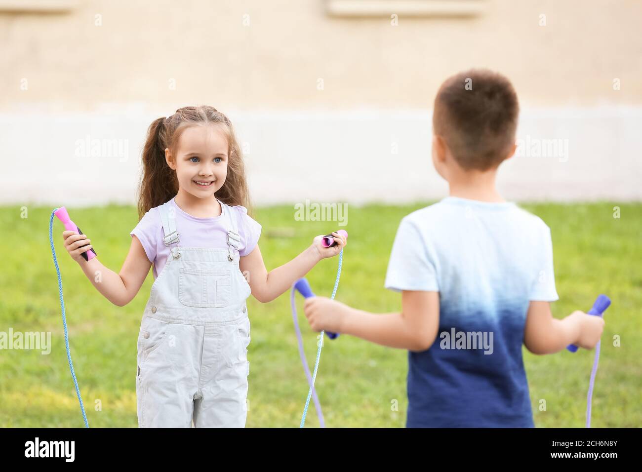 Cute little children jumping rope outdoors Stock Photo - Alamy