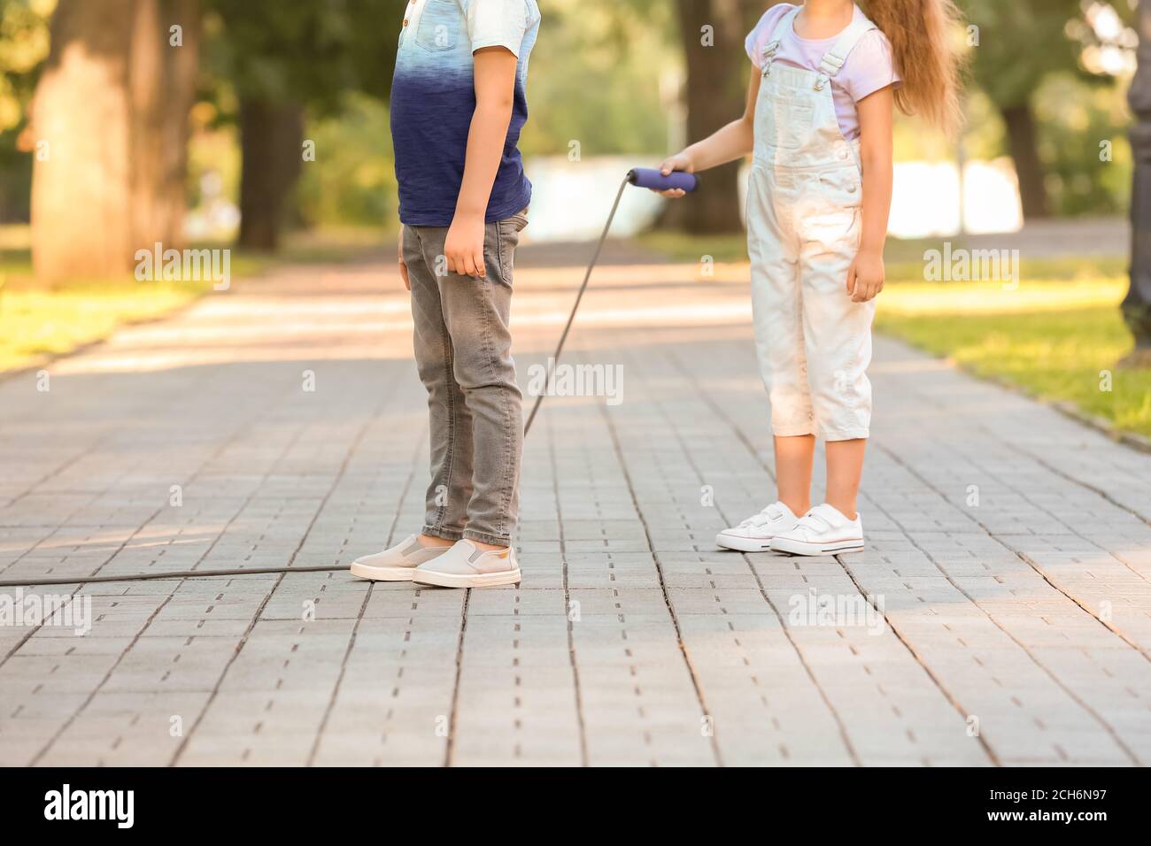 Cute little children jumping rope outdoors Stock Photo - Alamy