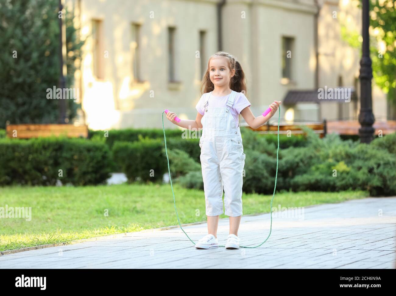 Cute little girl jumping rope outdoors Stock Photo - Alamy