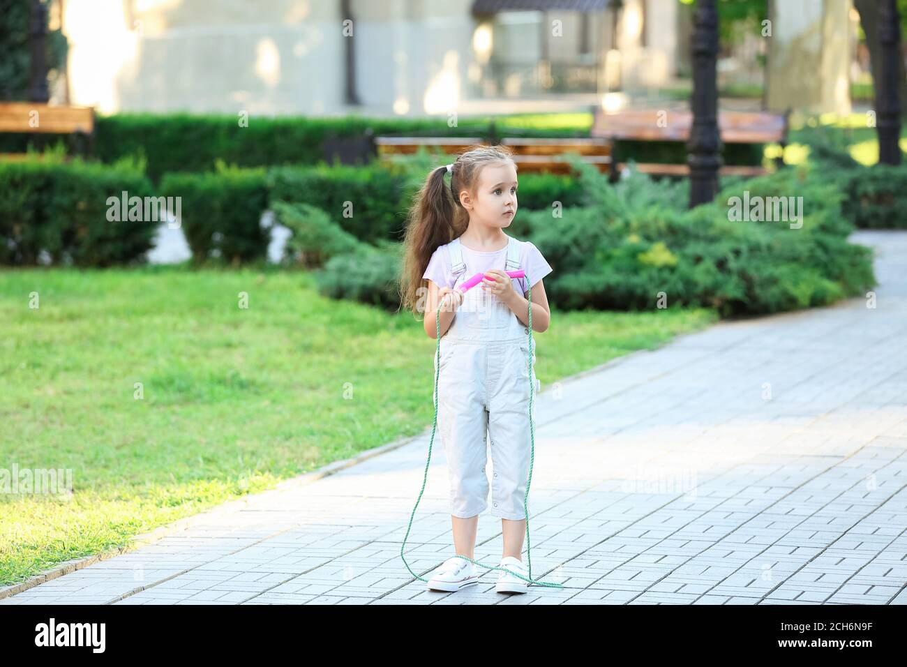 Cute little girl jumping rope outdoors Stock Photo - Alamy