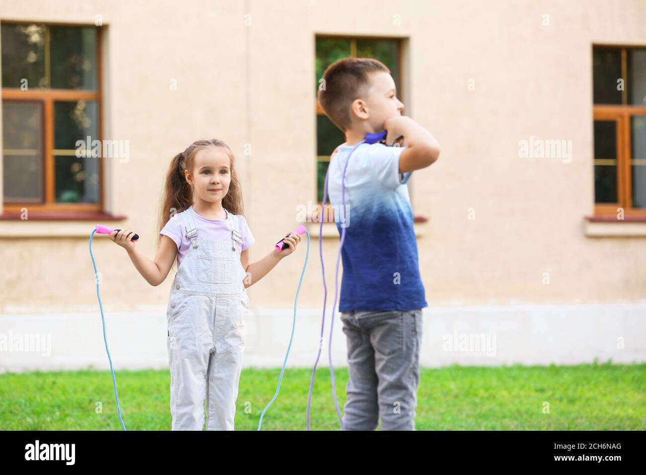 Cute little children jumping rope outdoors Stock Photo - Alamy