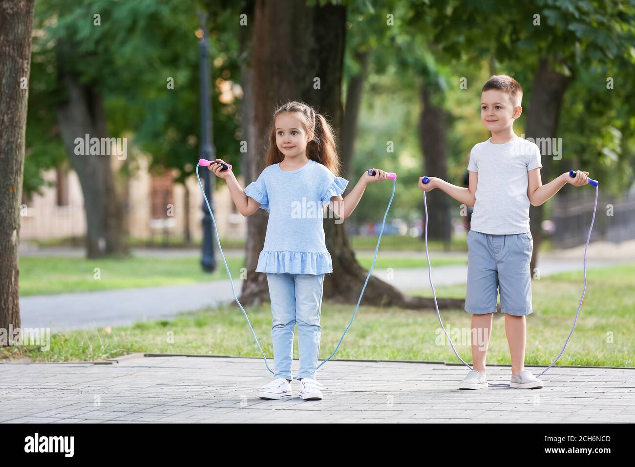 Cute little children jumping rope outdoors Stock Photo - Alamy