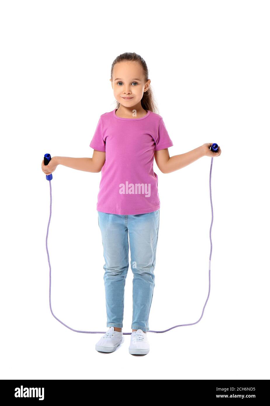 Cute little girl jumping rope against white background Stock Photo - Alamy