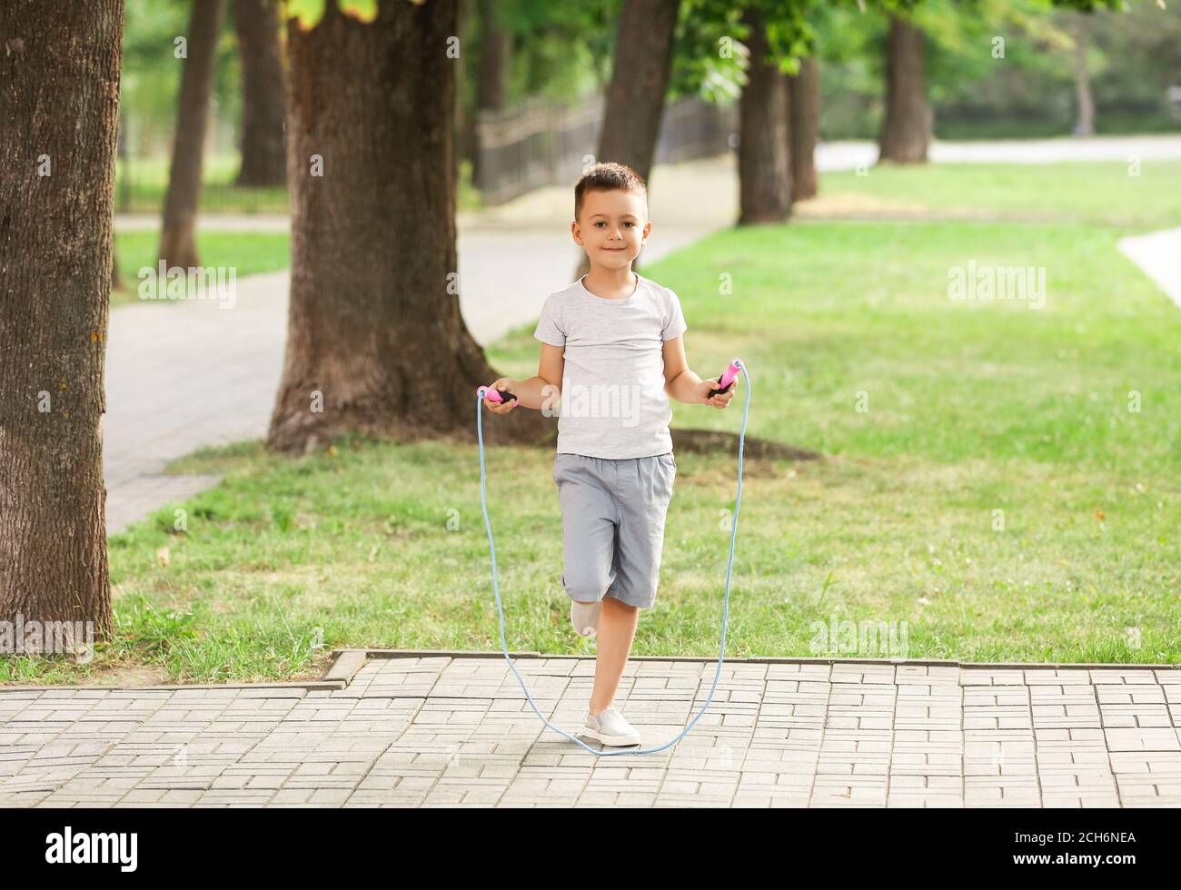 Cute little boy jumping rope outdoors Stock Photo - Alamy