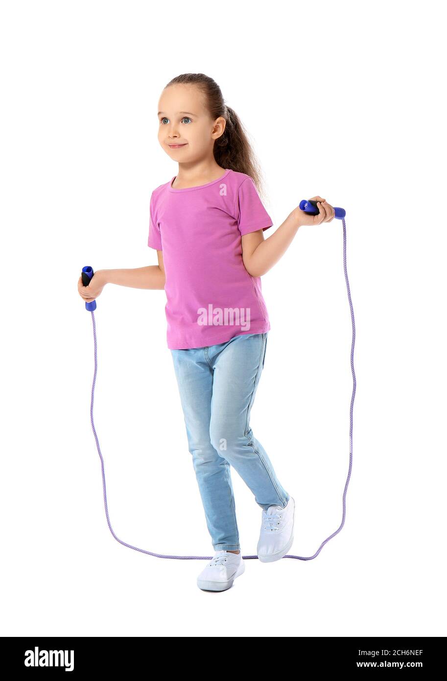 Cute little girl jumping rope against white background Stock Photo - Alamy