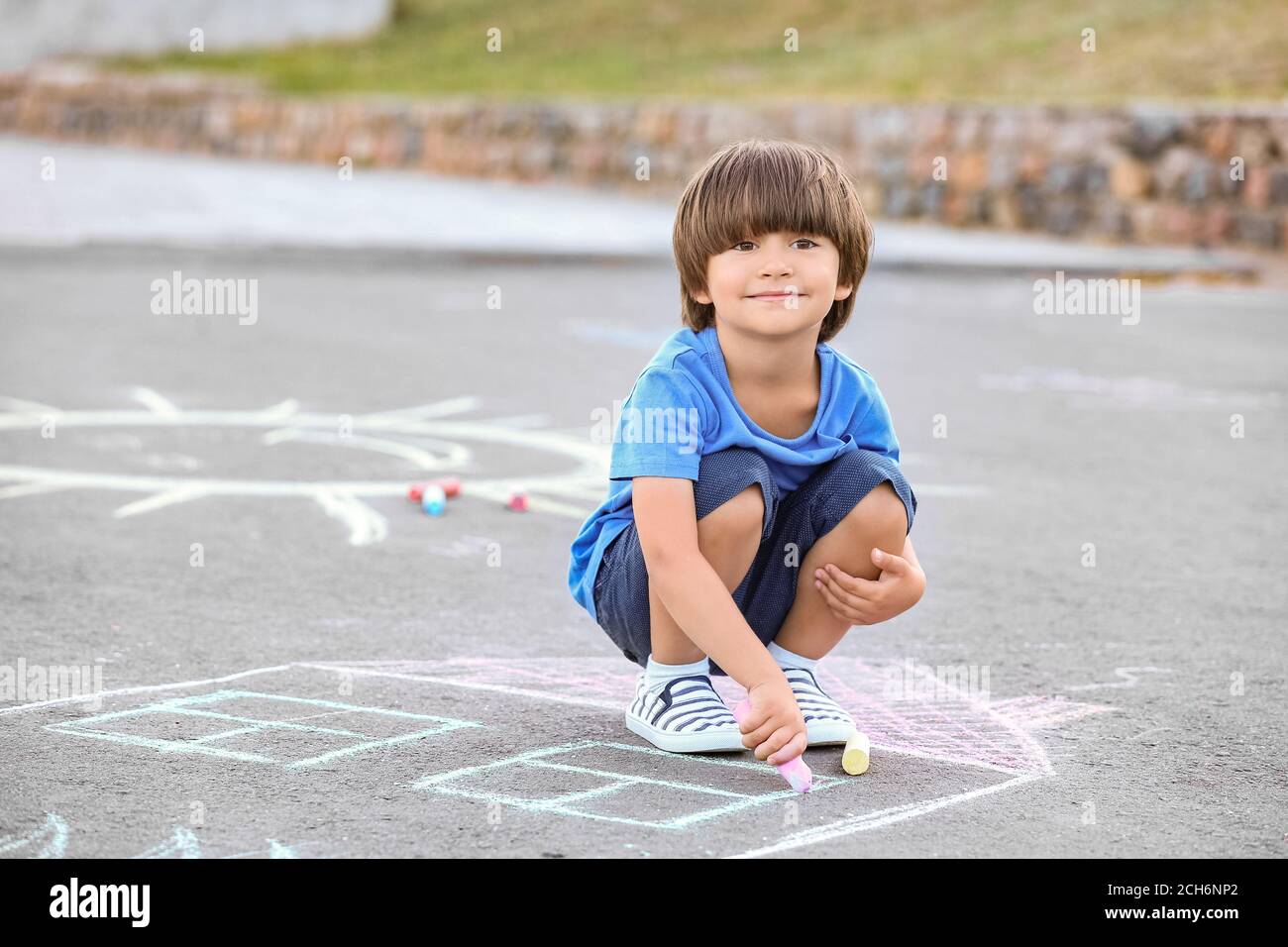 Little boy drawing with chalk on asphalt Stock Photo - Alamy