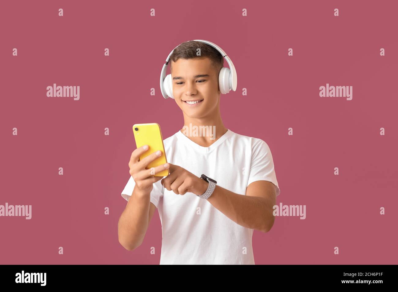 Teenage boy listening to music on color background Stock Photo - Alamy