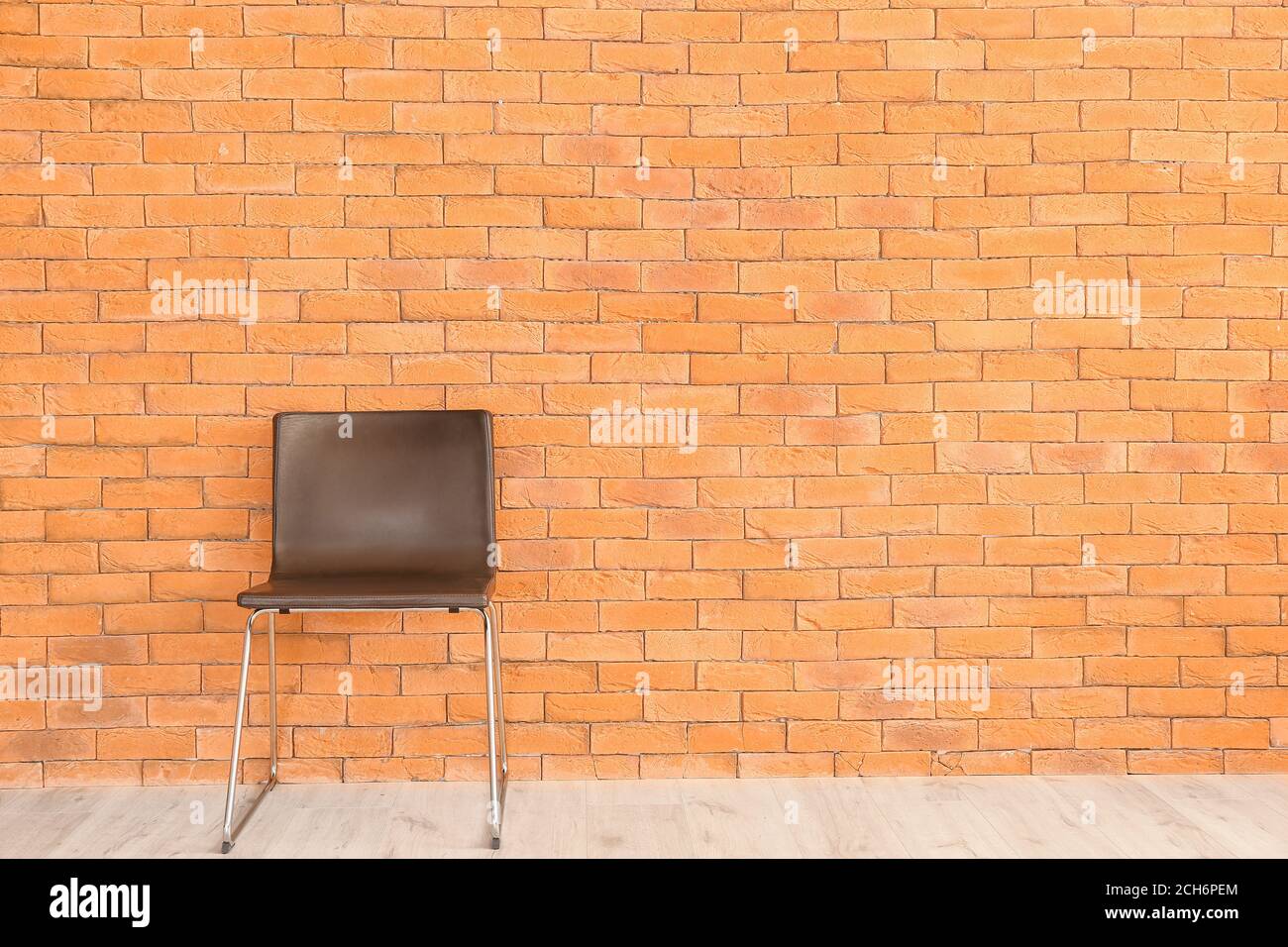 Modern chair near brick wall Stock Photo - Alamy