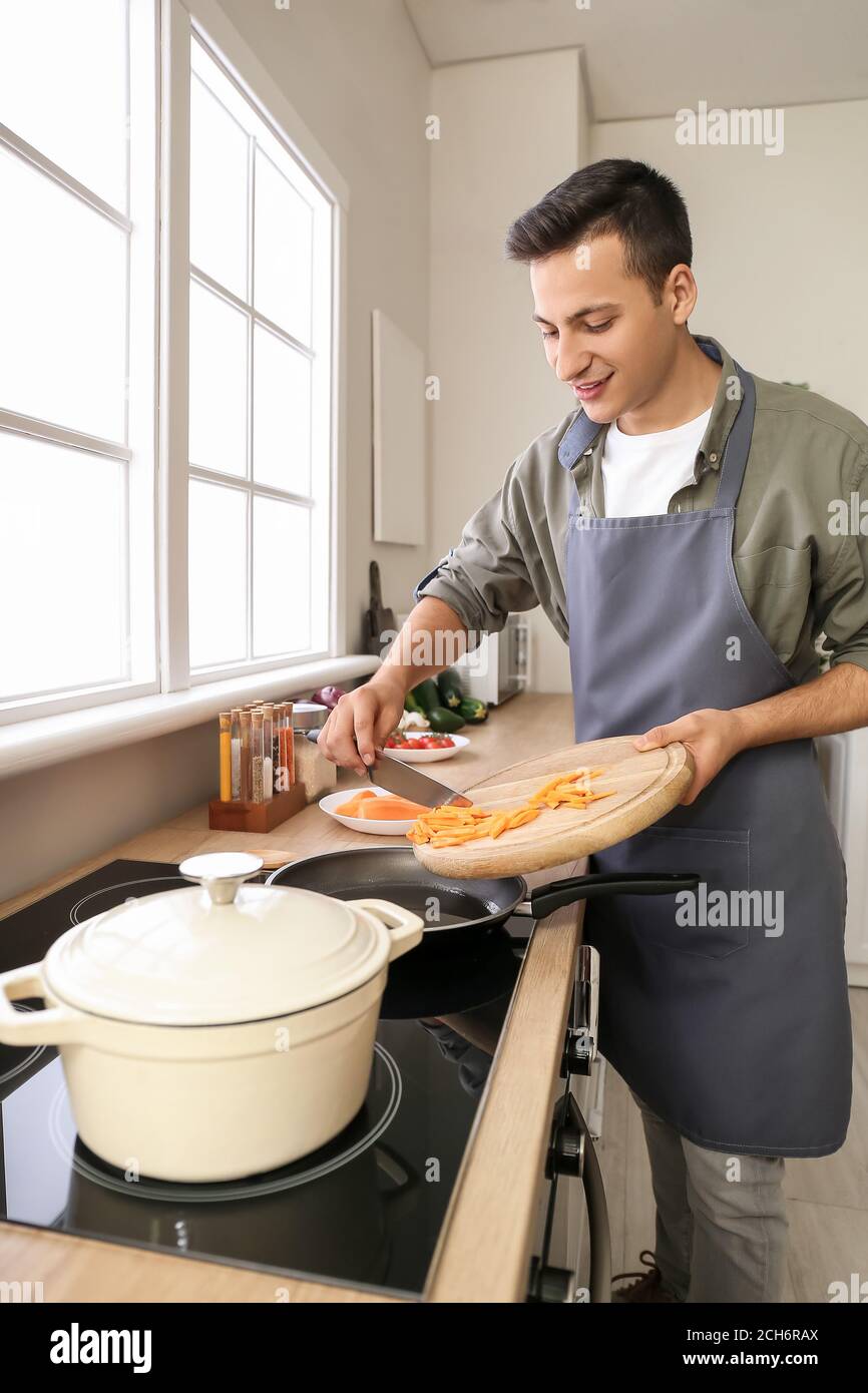 Young man cooking food in kitchen Stock Photo - Alamy