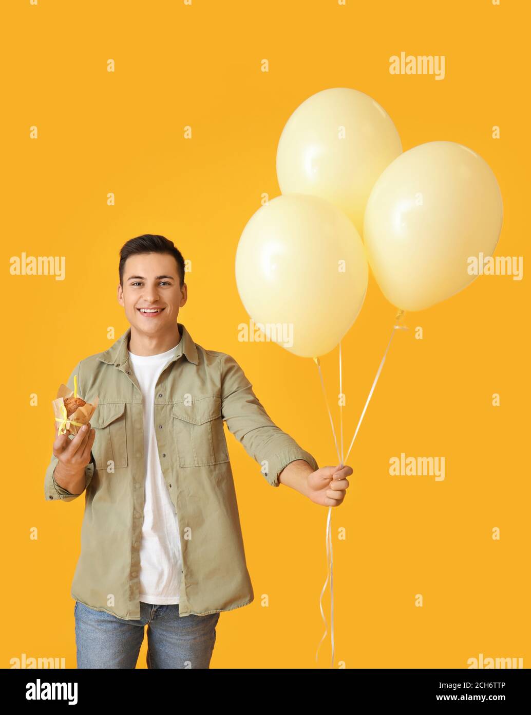 Young man with balloons and birthday cake on color background Stock ...