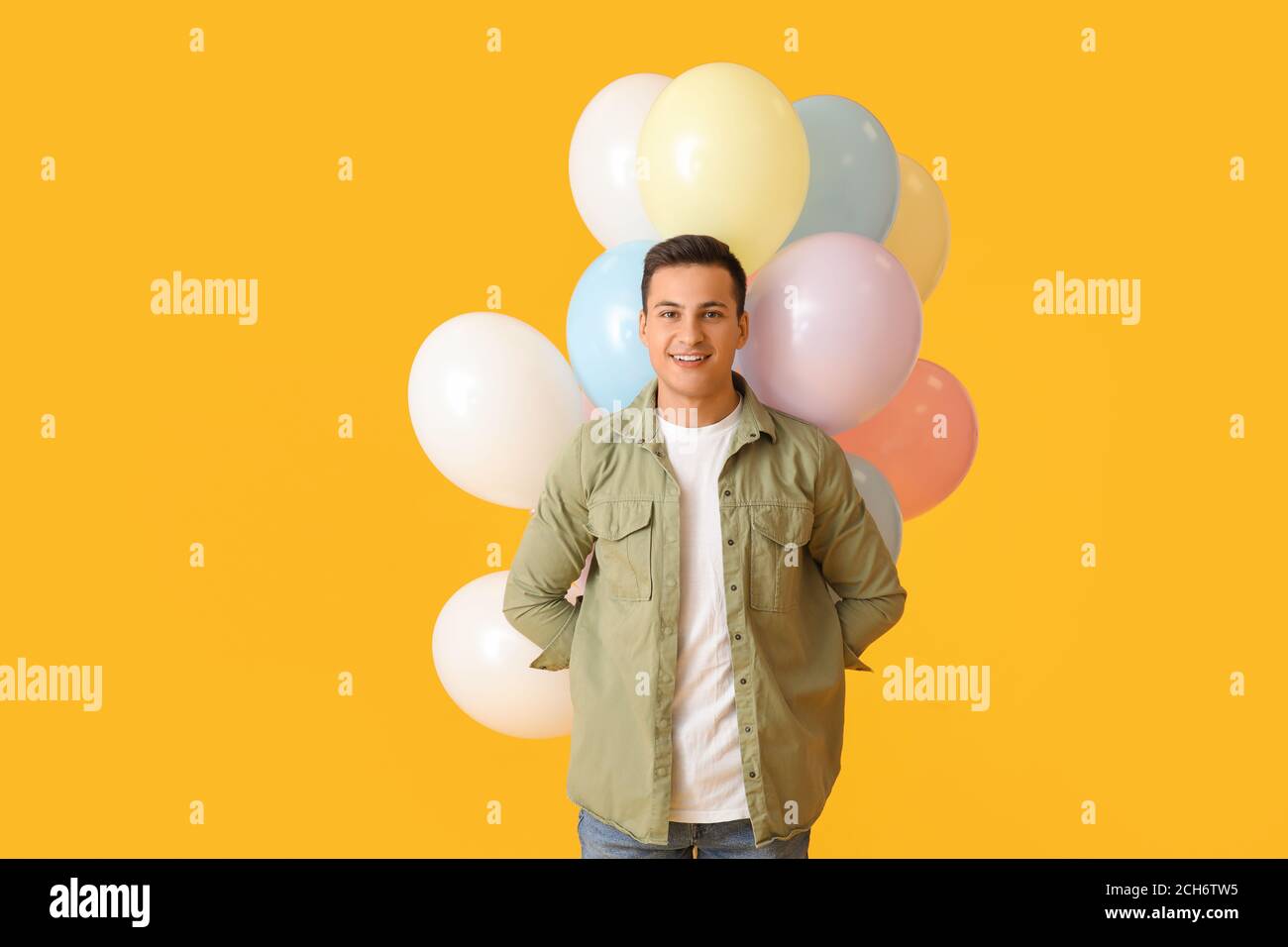 Young man with balloons on color background Stock Photo - Alamy