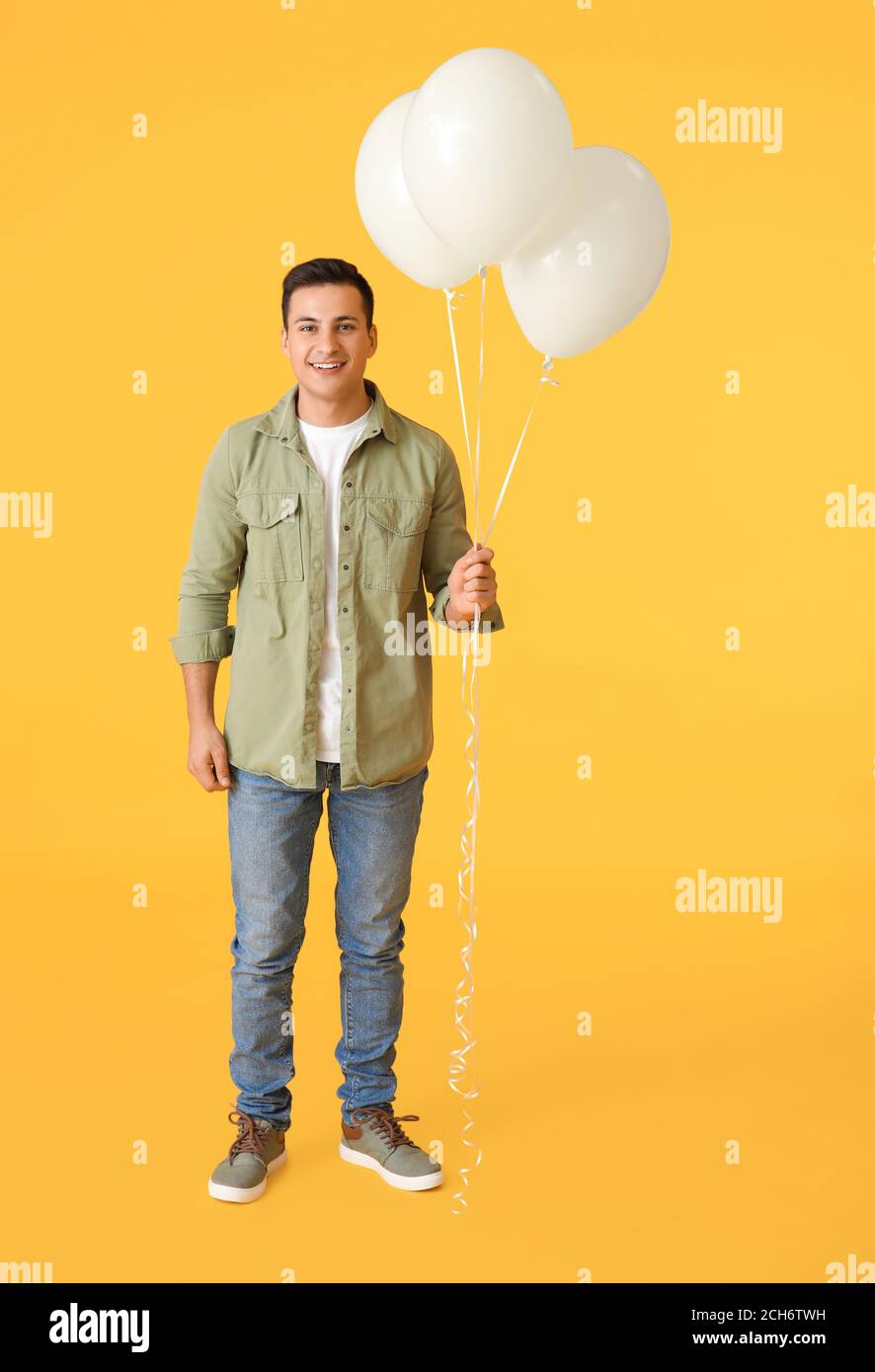 Young man with balloons on color background Stock Photo - Alamy