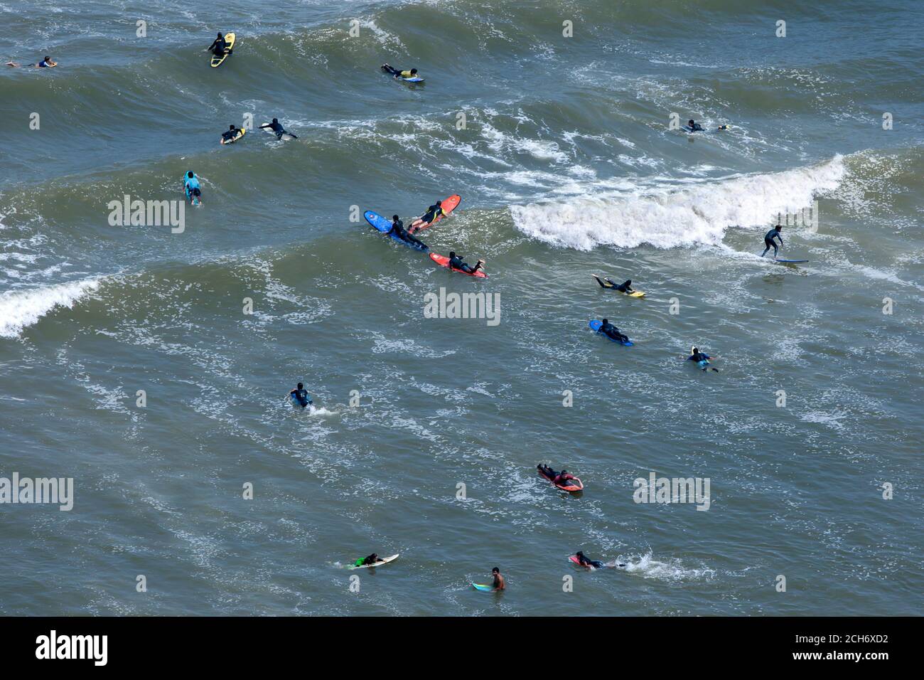 Surfers catching waves in the Pacific Ocean off the coast of Lima in ...