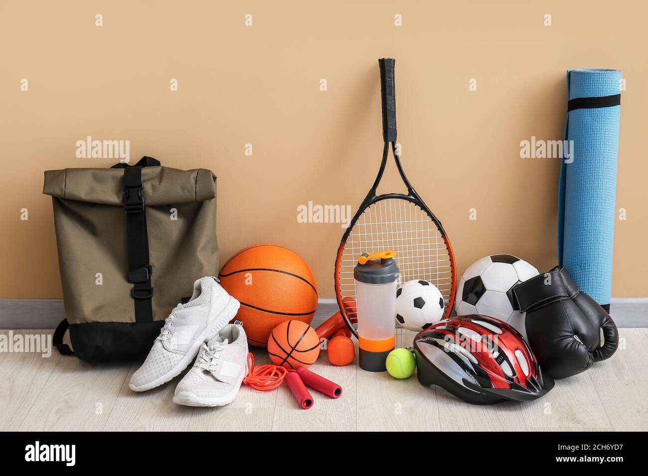 Set of sport equipment on floor near color wall Stock Photo - Alamy