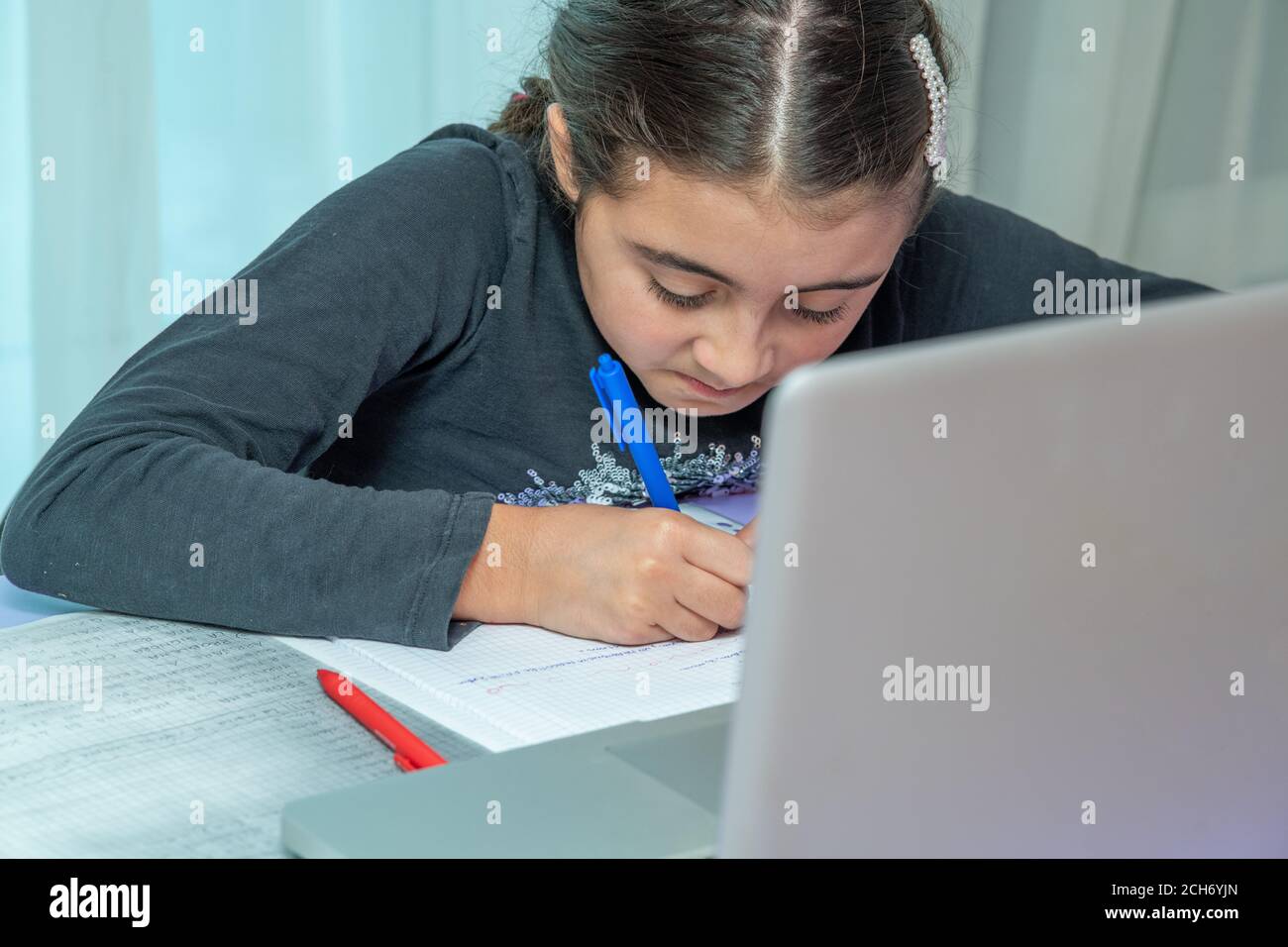 Smart school concept. Young girl at home making school homework with ...