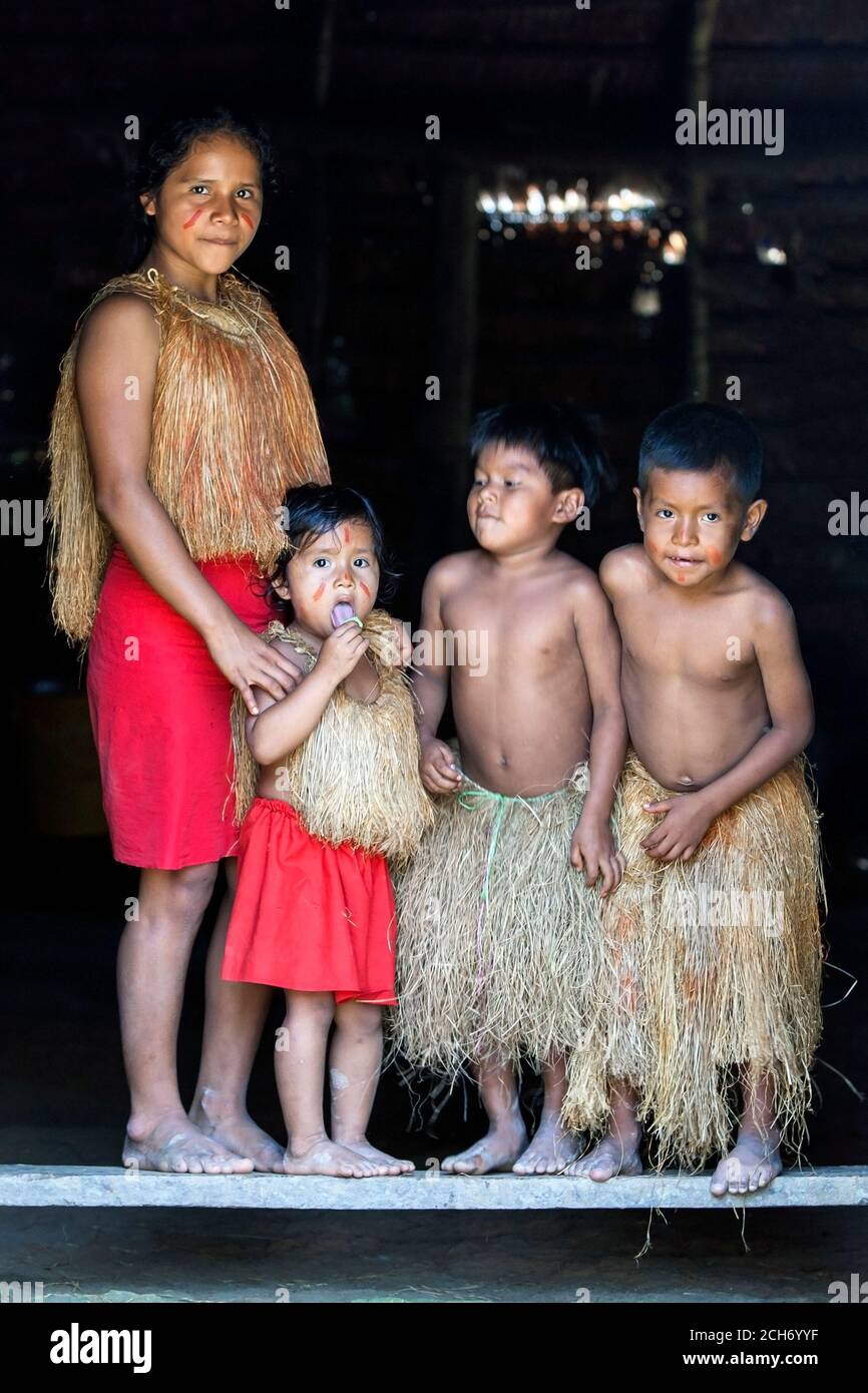 Children dressed in traditional Peruvian dress standing inside a hut in ...