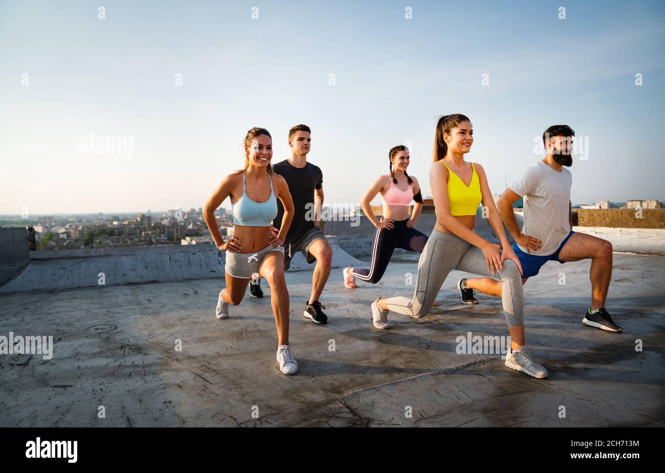 Group of cheerful fit fitness team exercising together outdoor Stock ...