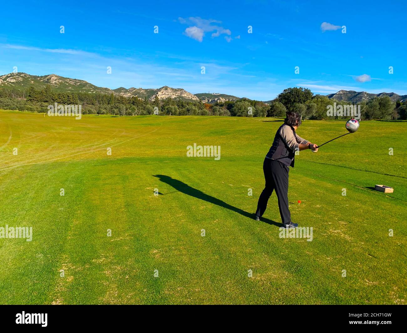 Golfer Teeing Off with Driver and with Mountain View in France Stock ...