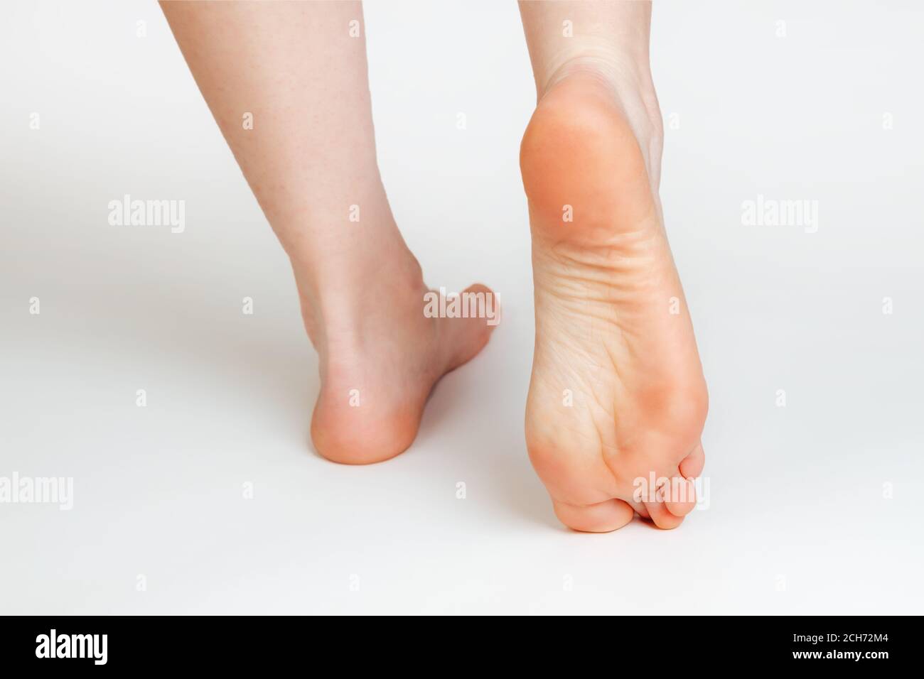 Women's smooth and beautiful feet, on a white background. The soles of ...