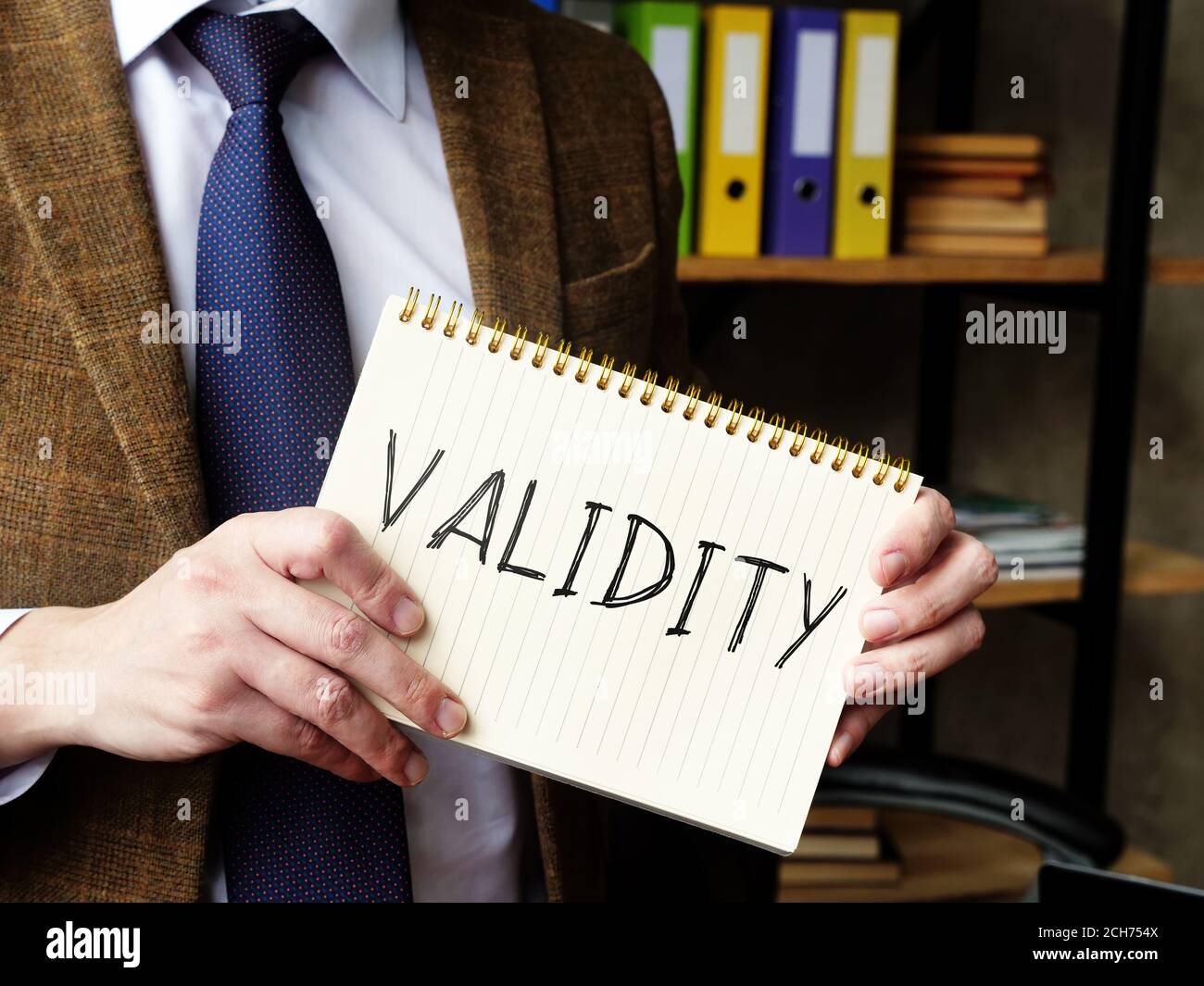Validity concept. A man in a suit holds a handwritten lettering Stock Photo - Alamy