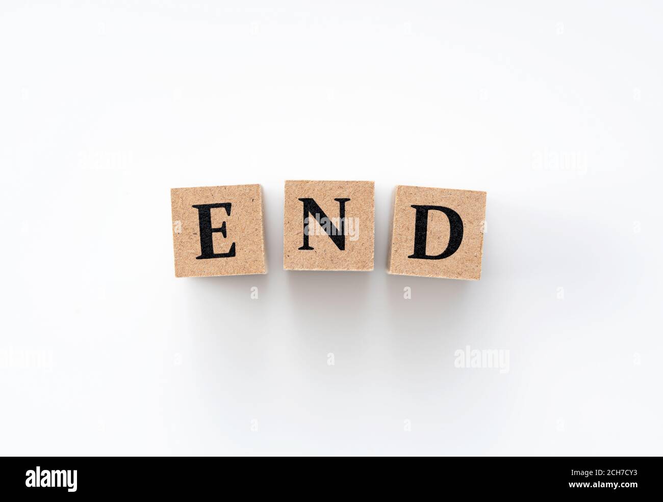 A wooden block with the word END written on it on a white background ...