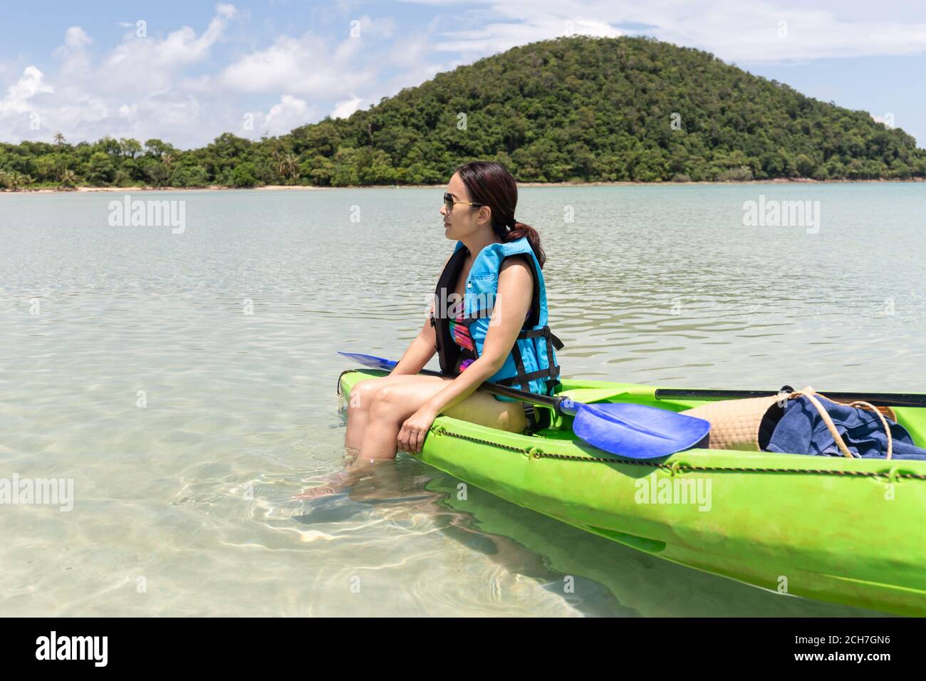 Tourist woman sitting on kayak lookign at beautiful tropical beach on ...