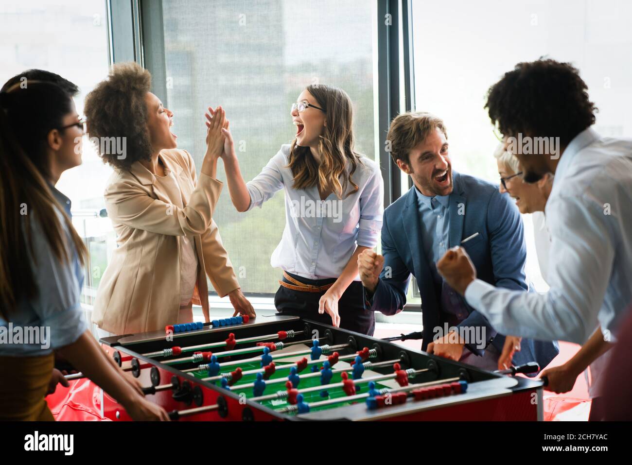 Excited diverse employees enjoying funny activity at work break ...