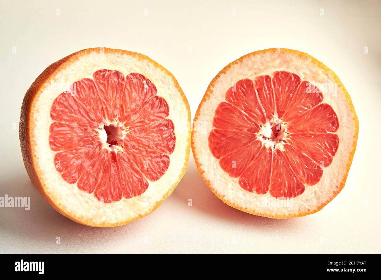 Two halfs of fresh ripe grapefruit on a light background, food concept ...