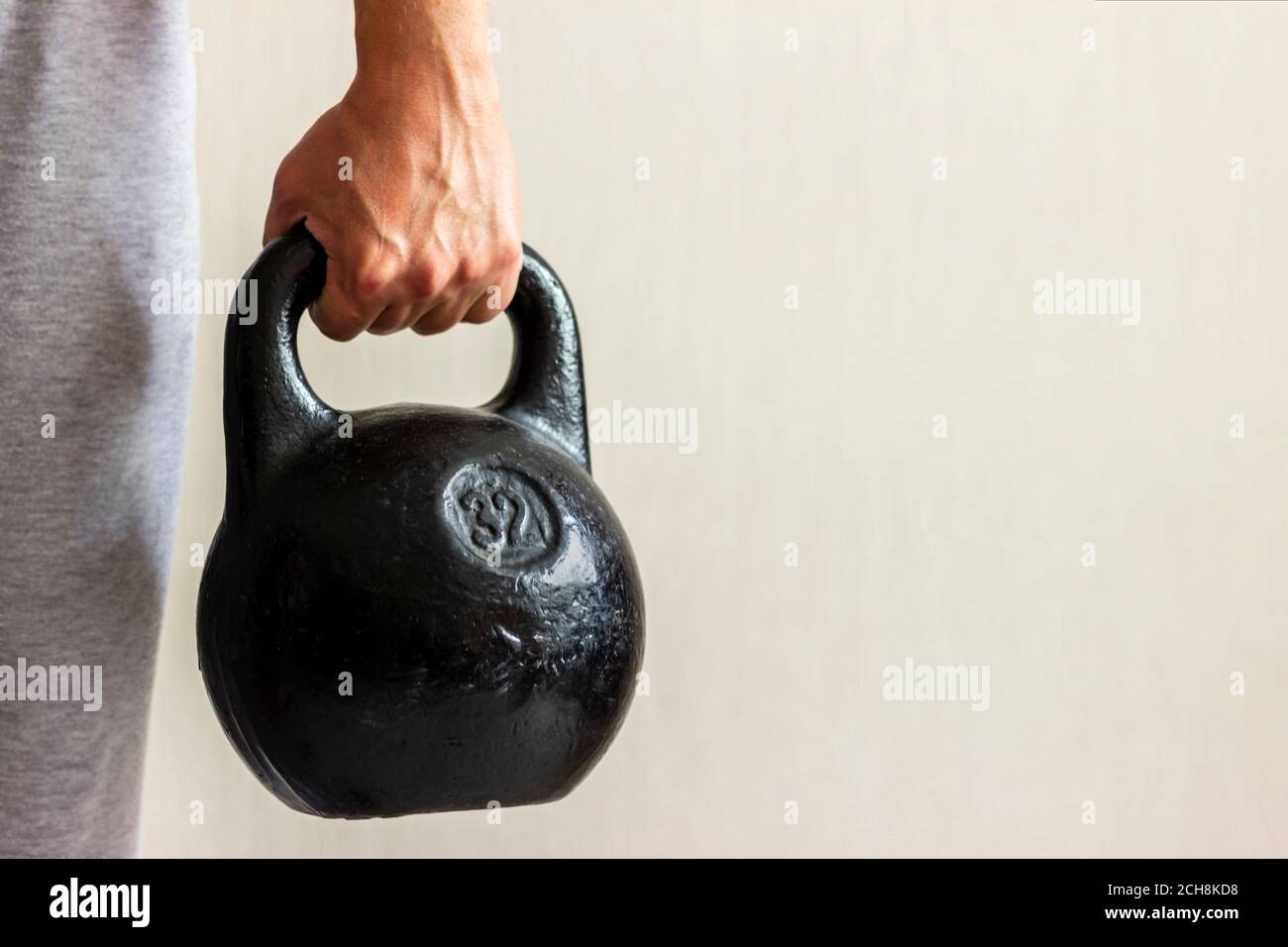 Strong male hand holding a two-pound cast-iron weight close-up Stock ...